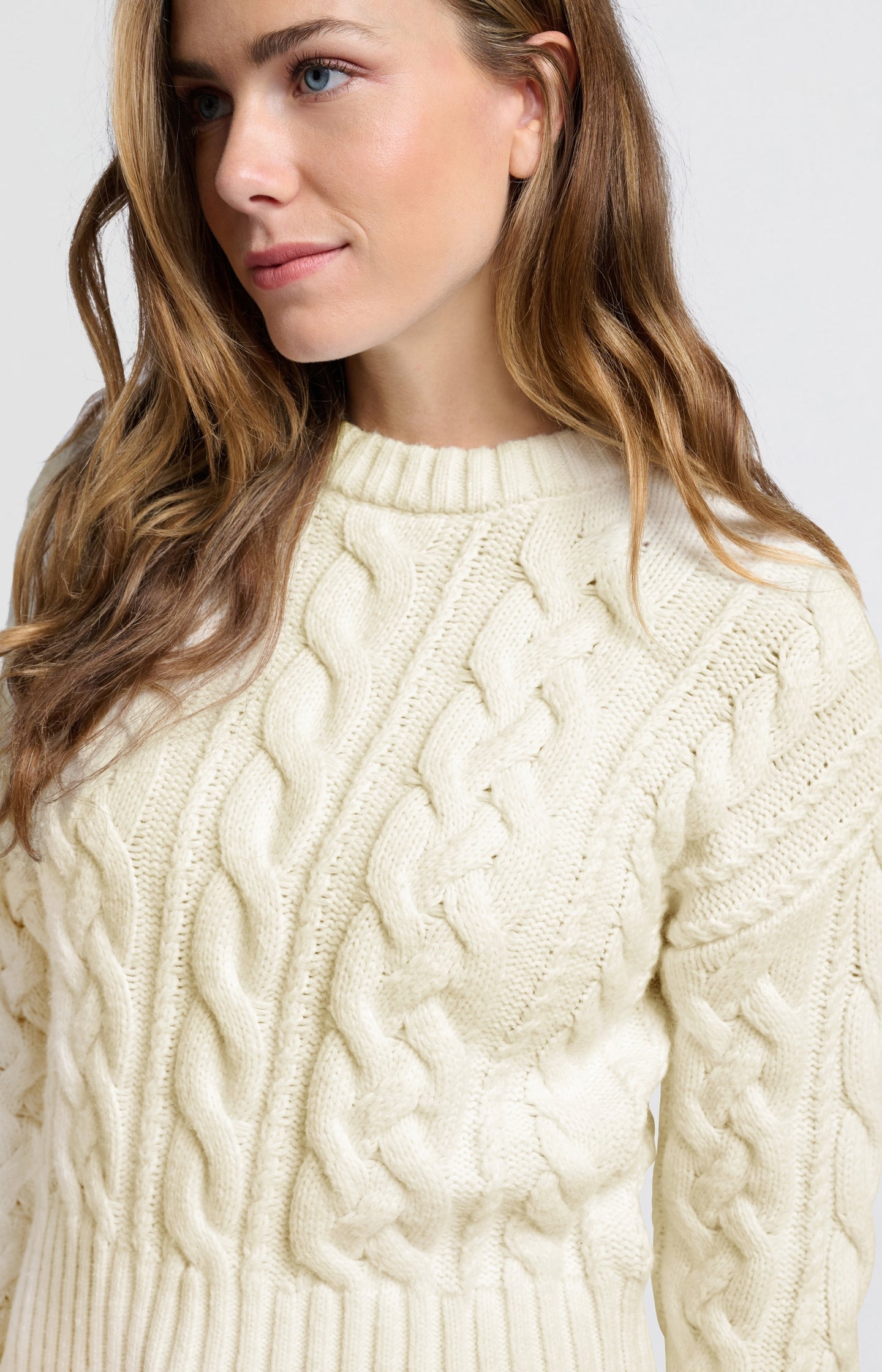 Cream-colored cable sweater with round neck and long sleeves